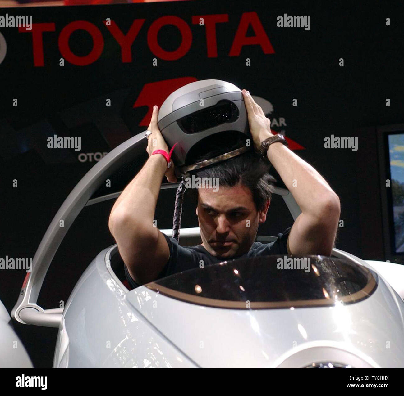 A driver adjusts his virtual reality race helmet before demonstrating ...