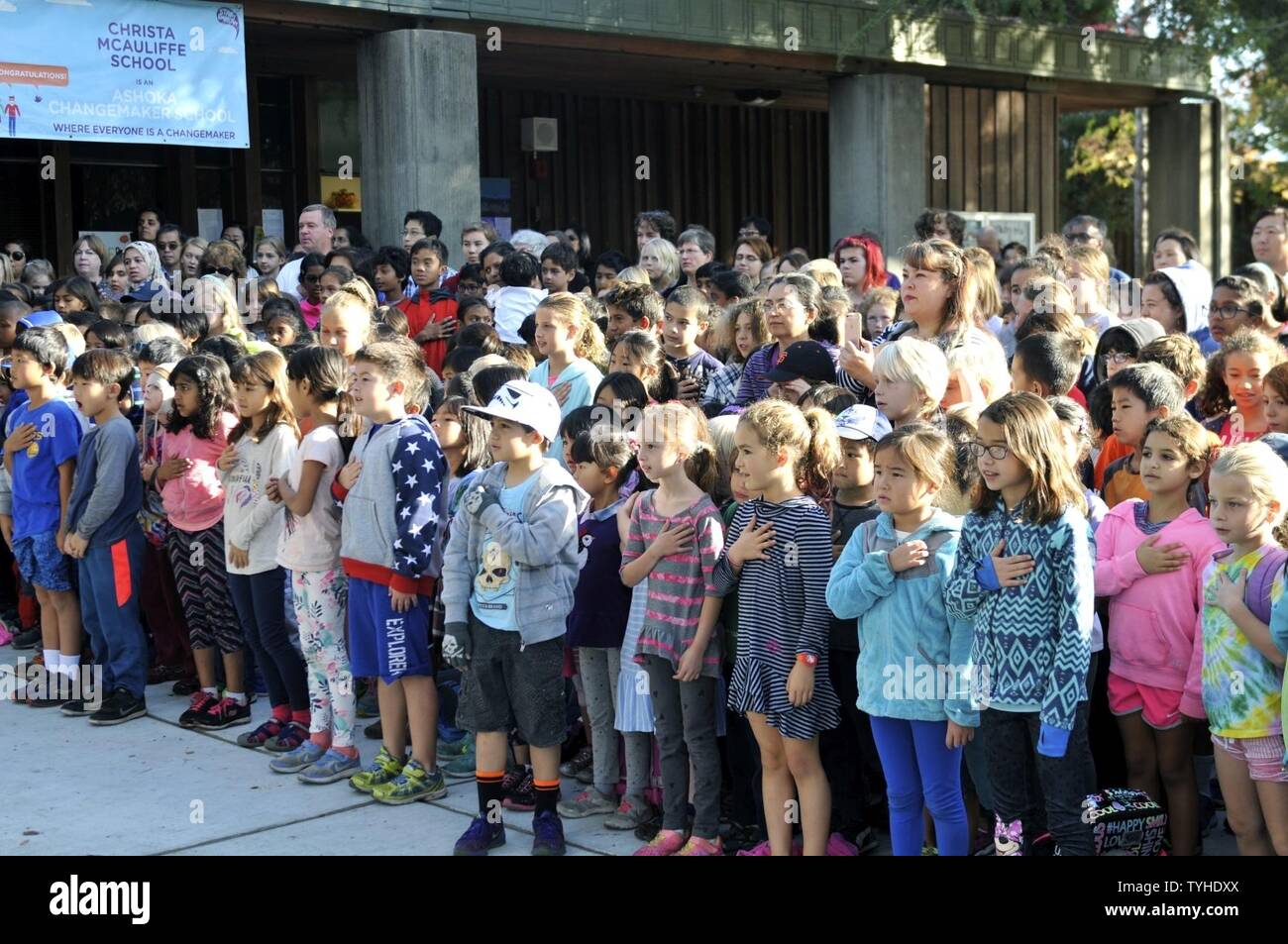 Elementary students recite the Pledge of Allegiance at a flag raising ...