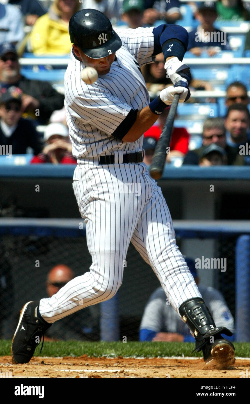 Derek Jeter of the New York Yankees check swings at a ball pitched by ...