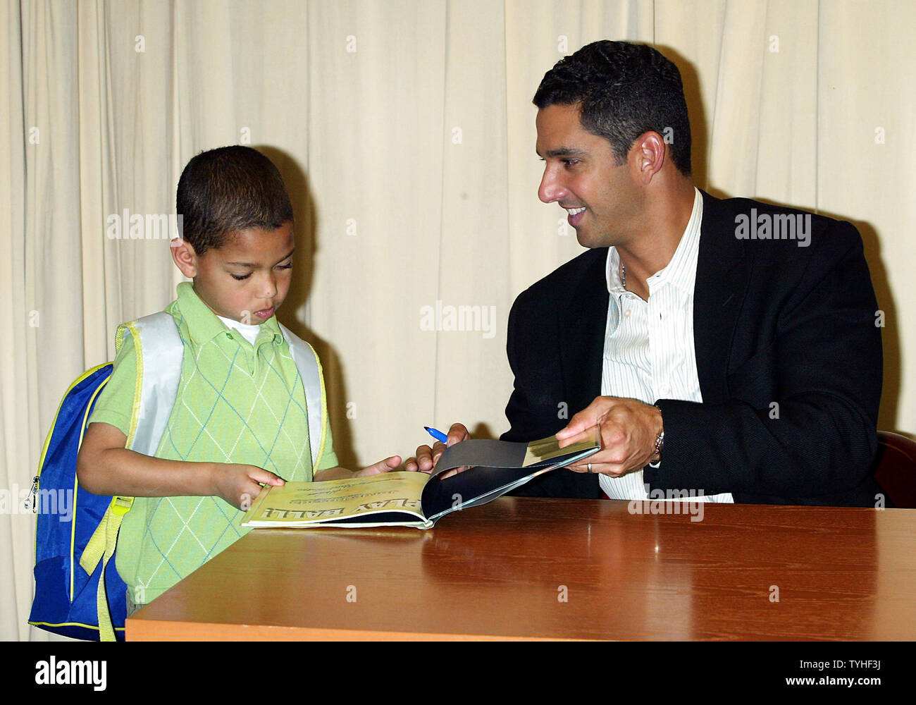 Jorge Posada signs a copy of his new book "Play Ball" for Jonathan, a ...
