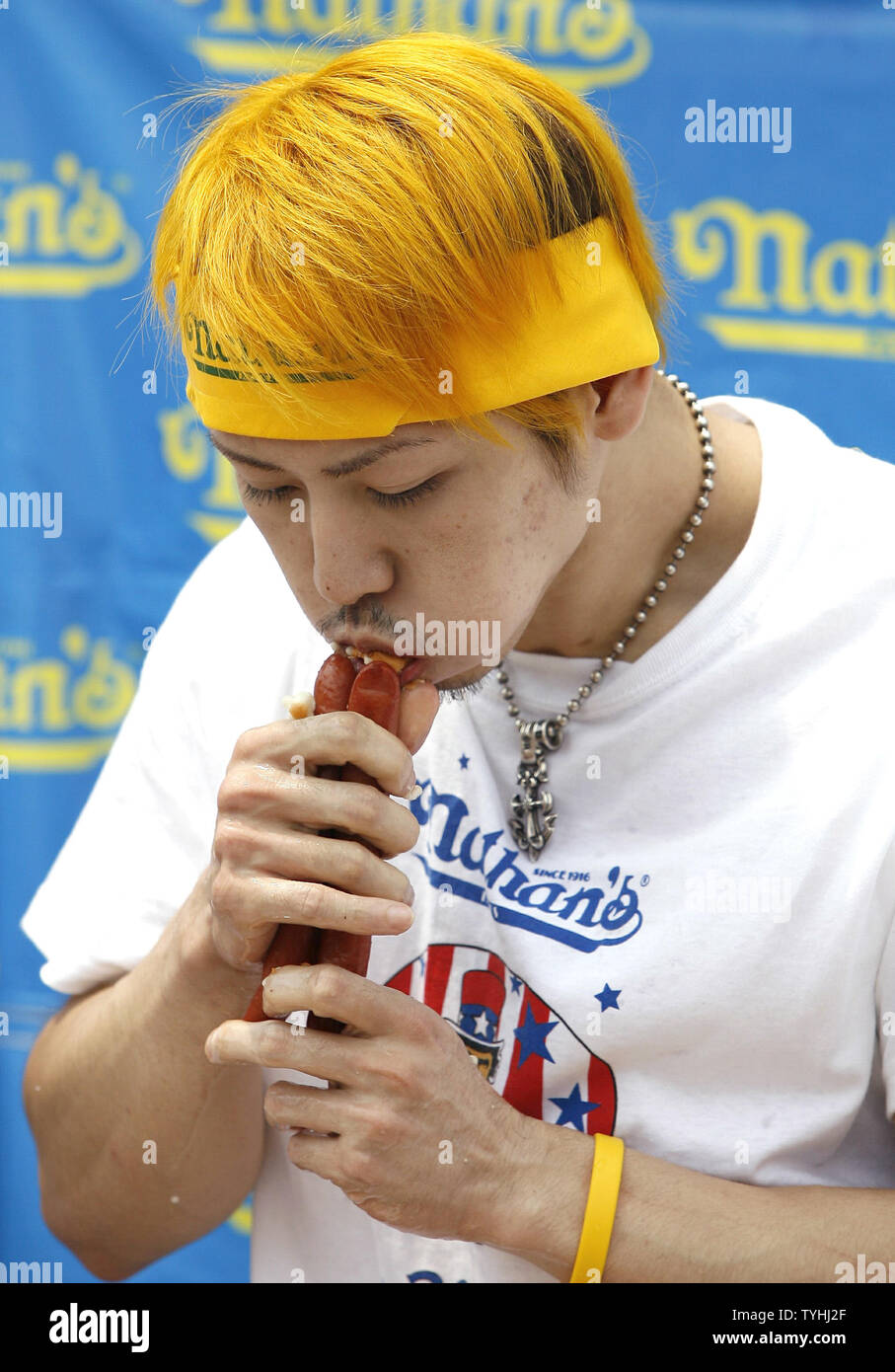 Japanese champion Takeru Kobayashi forces 2 hot dogs in his mouth in ...