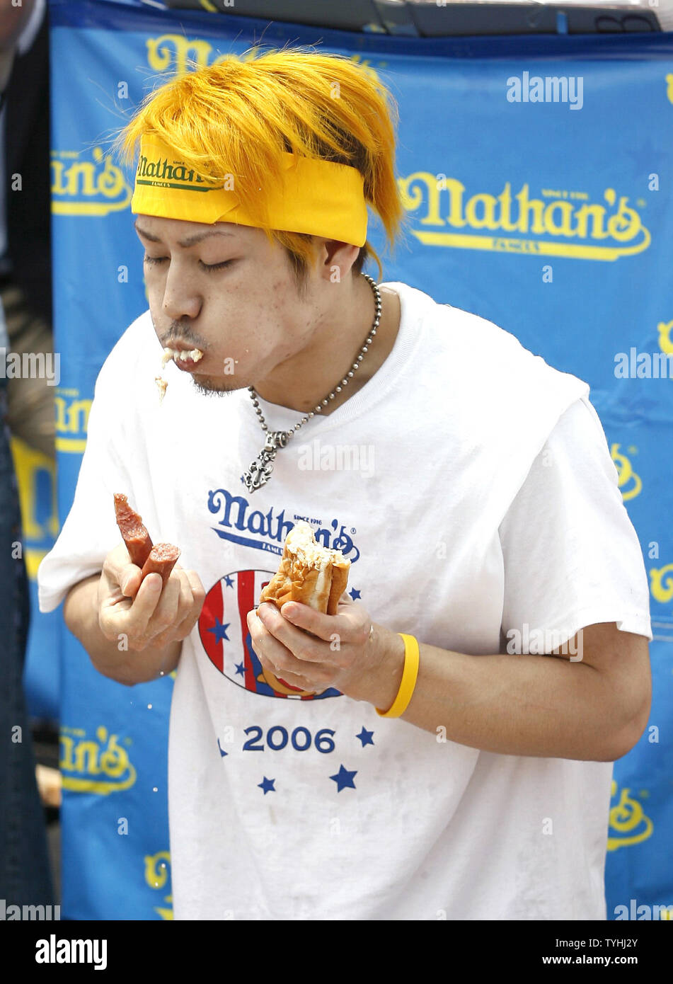 Japanese champion Takeru Kobayashi forces 2 hot dogs in his mouth in ...