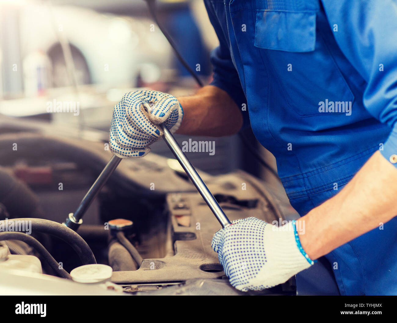 mechanic man with wrench repairing car at workshop Stock Photo - Alamy