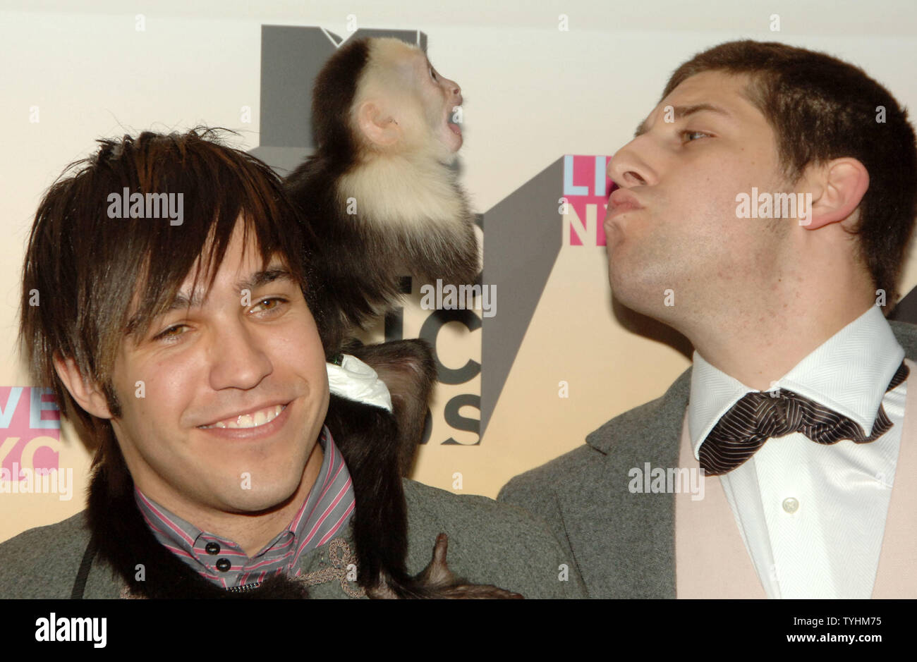 Fall Out Boy band members play with their pet monkey as they arrive at ...