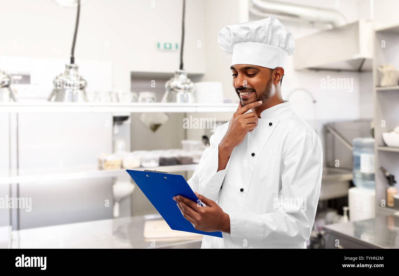indian chef with clipboard at restaurant kitchen Stock Photo - Alamy