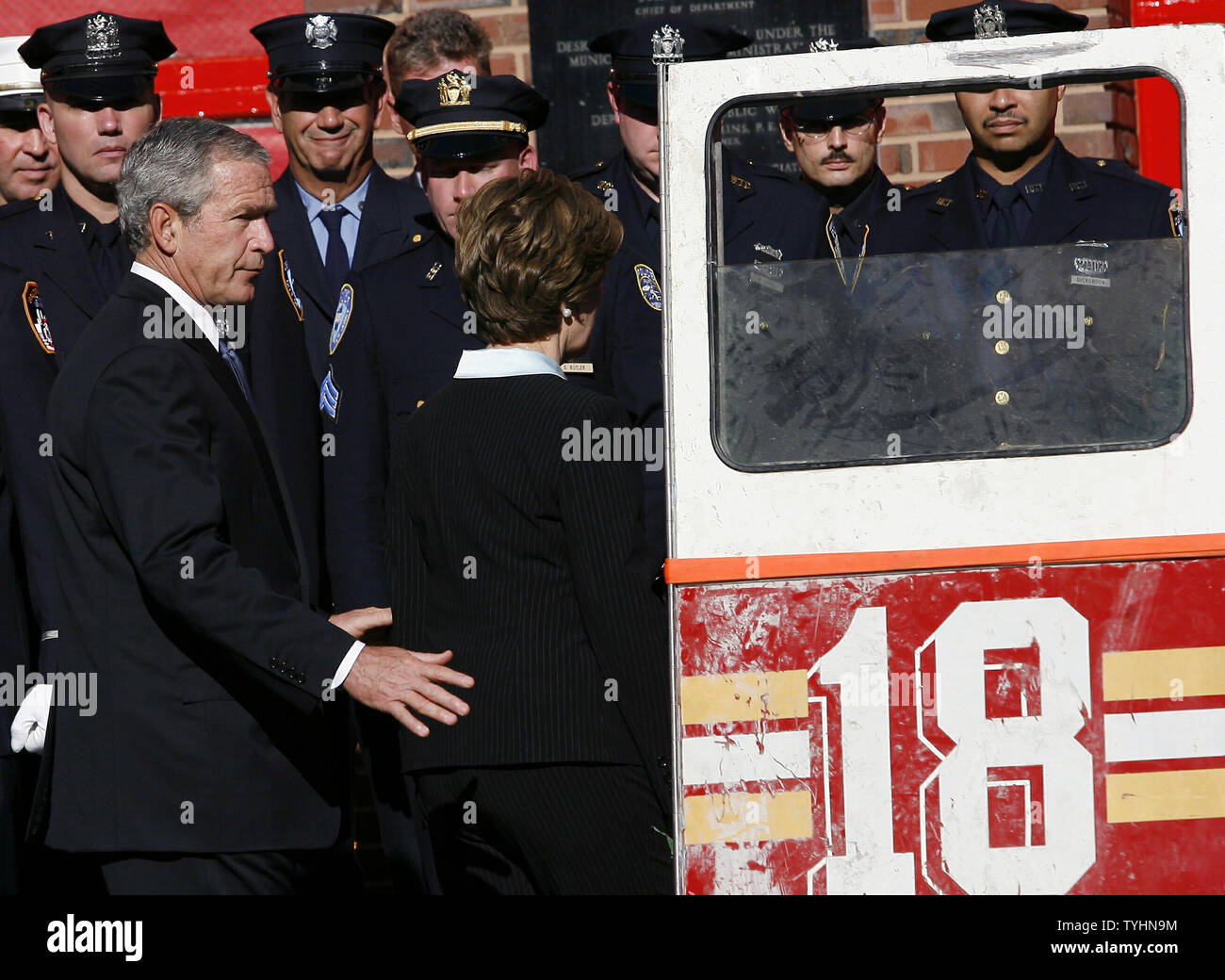 President George W. Bush reaches to touch the fire engine door during ...