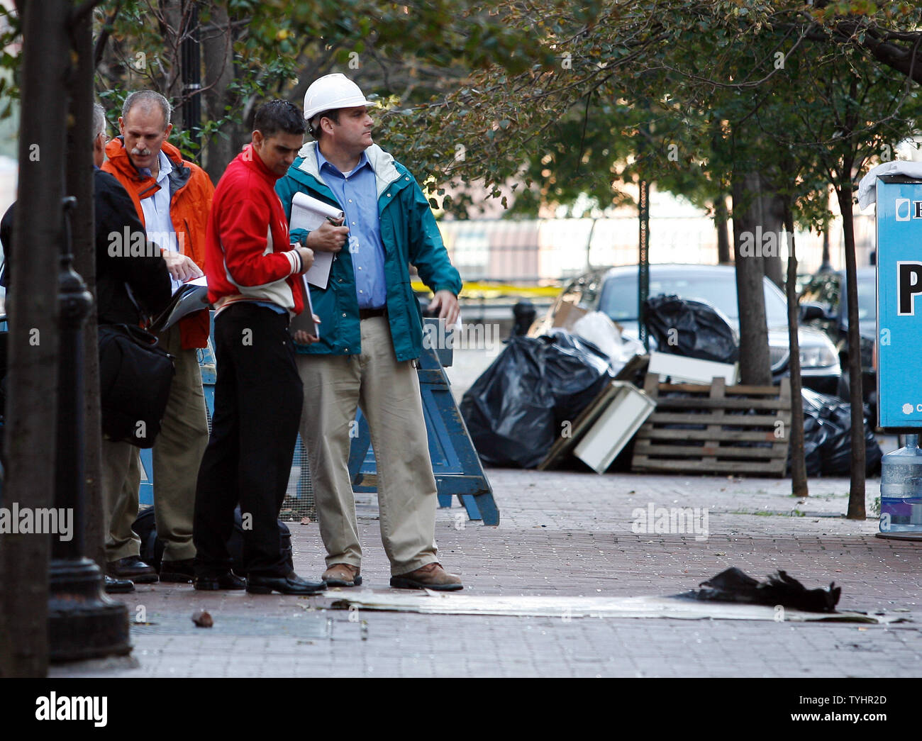 Investigators talk while standing over the wing from the plane of New ...