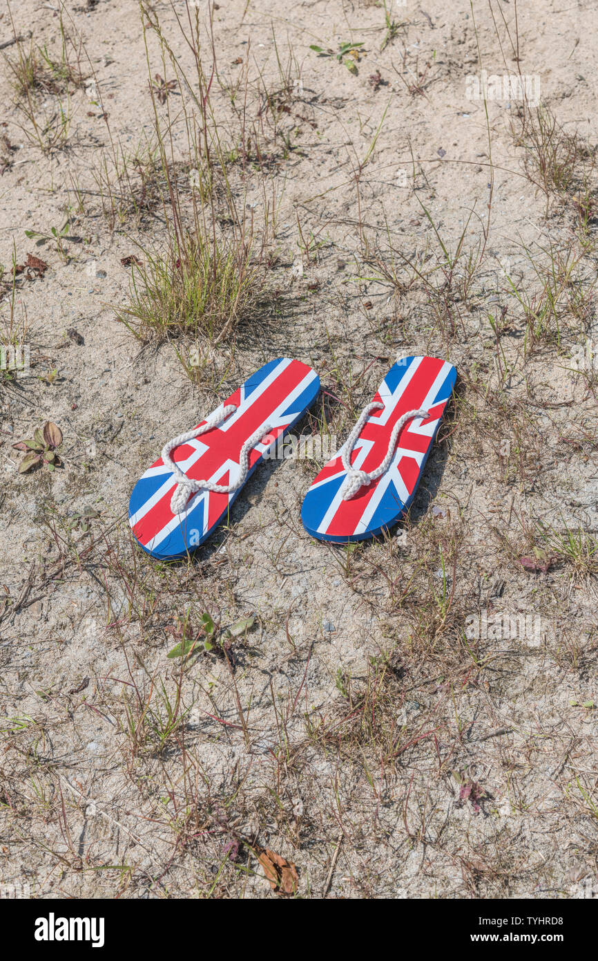 Union Jack flip-flops on grass-sand surface. For 2021 UK staycation ...