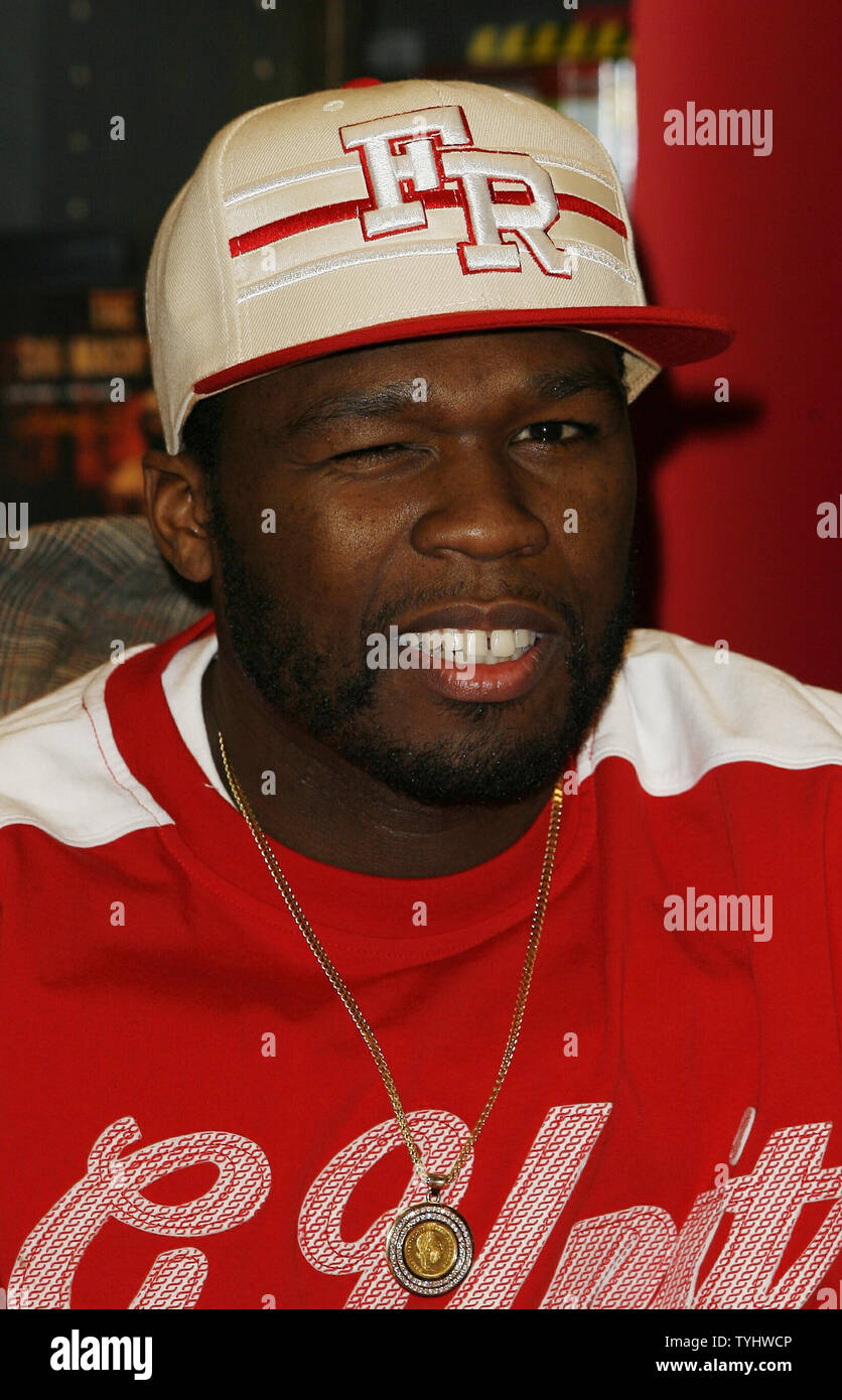 50 Cent winks while he signs copies of "Death Before Dishonor", "Baby ...