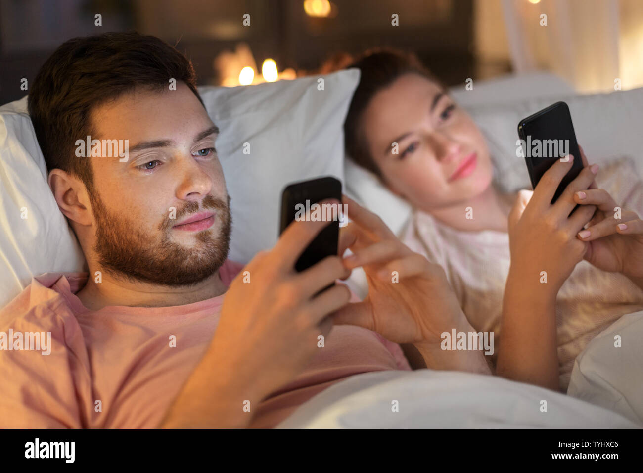 couple using smartphones in bed at night Stock Photo - Alamy