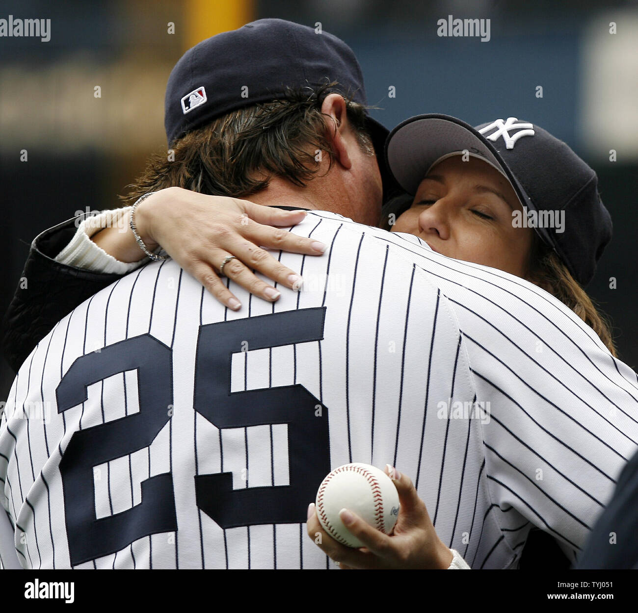 Jason Giambi embraces Melanie Lidle before she throws the first pitch in honor of her husband ...