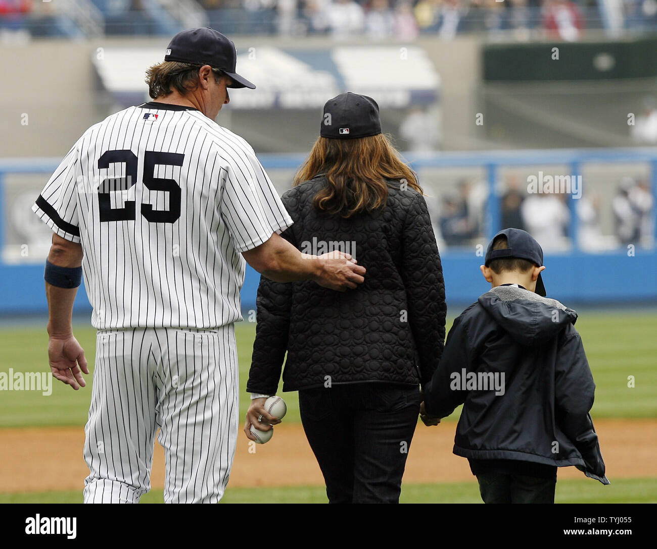 Melanie and Christopher Lidle walk to the mound with Jason Giambi ...