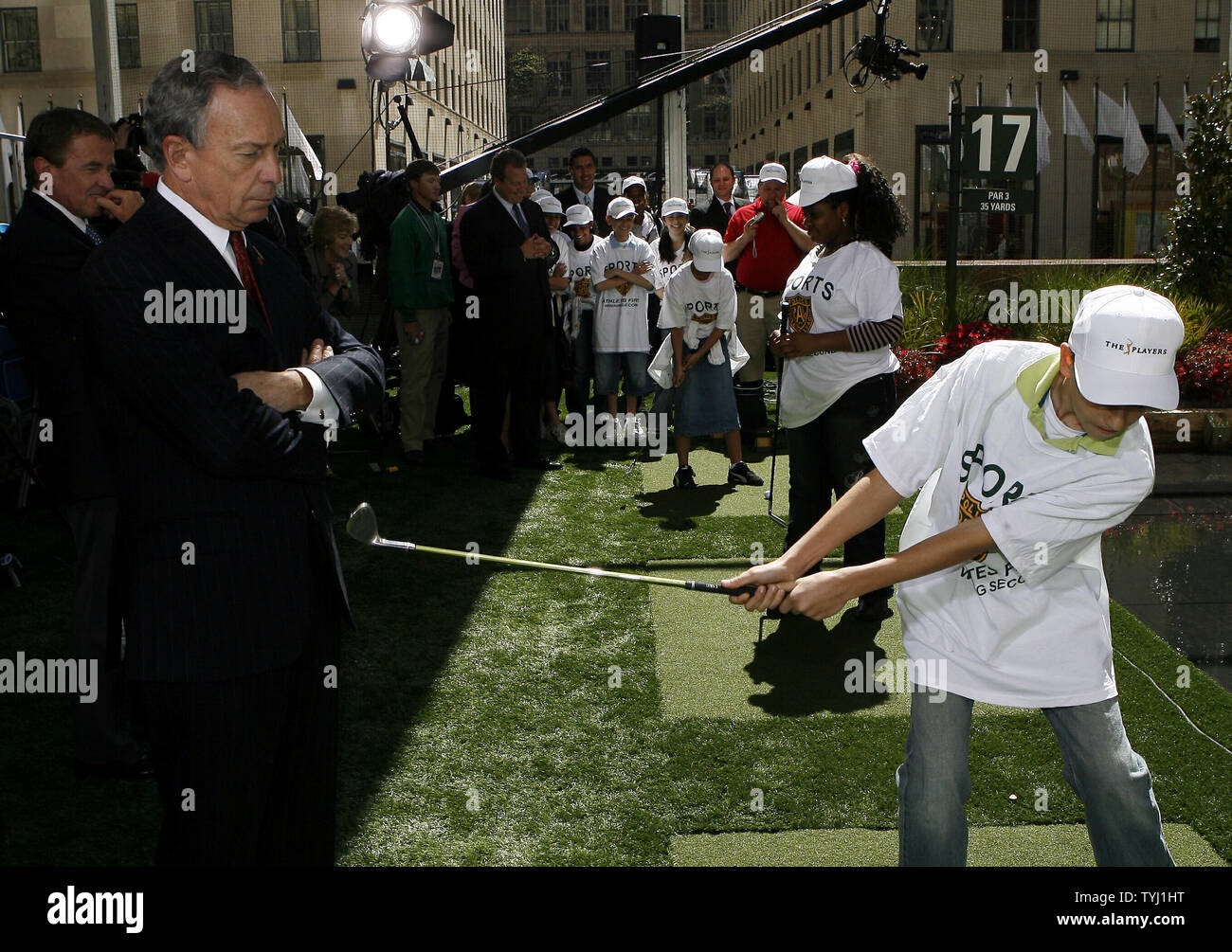 Mayor Michael Bloomberg helps a child from the Police Athletic League ...