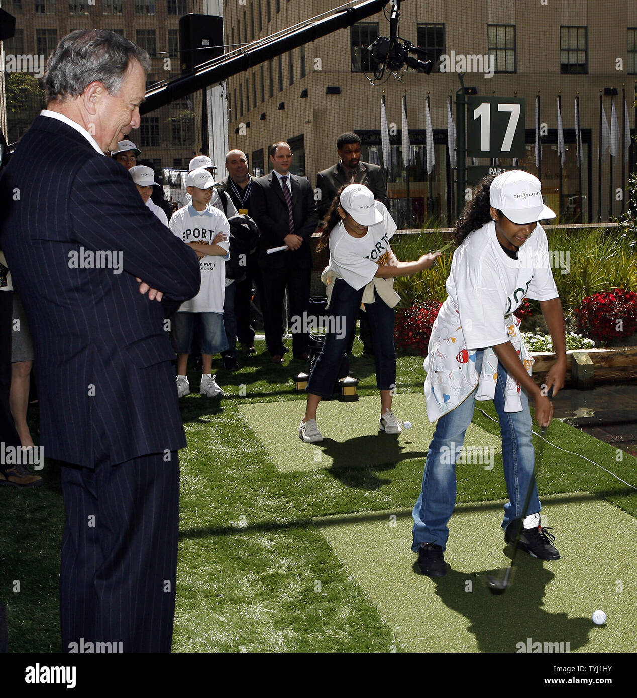 Mayor Michael Bloomberg helps a child from the Police Athletic League ...