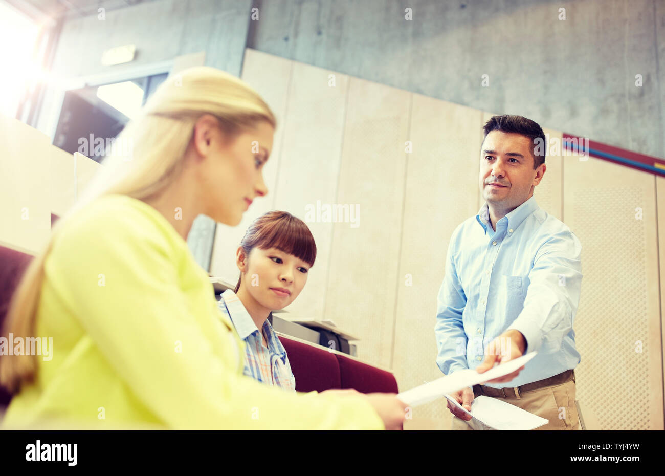 teacher giving exam tests to students at lecture Stock Photo - Alamy