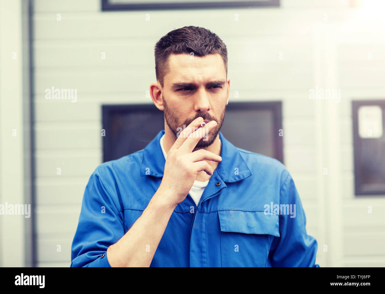 auto mechanic smoking cigarette at car workshop Stock Photo - Alamy