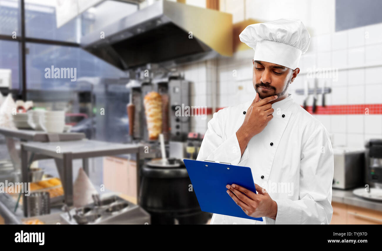 indian chef with menu on clipboard at kebab shop Stock Photo - Alamy