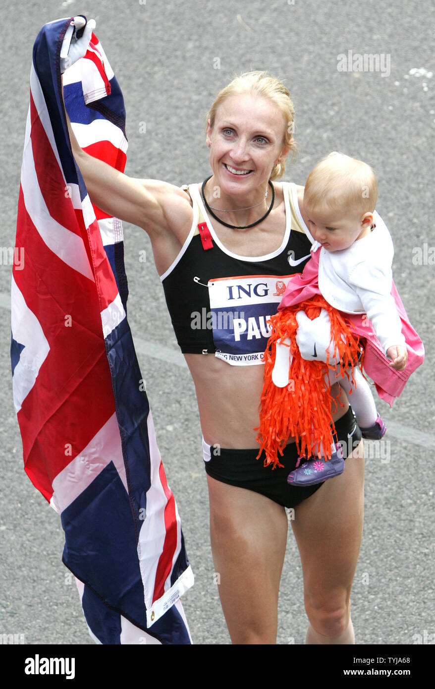 Paula Radcliffe of Great Britain celebrates with flag in one hand and ...