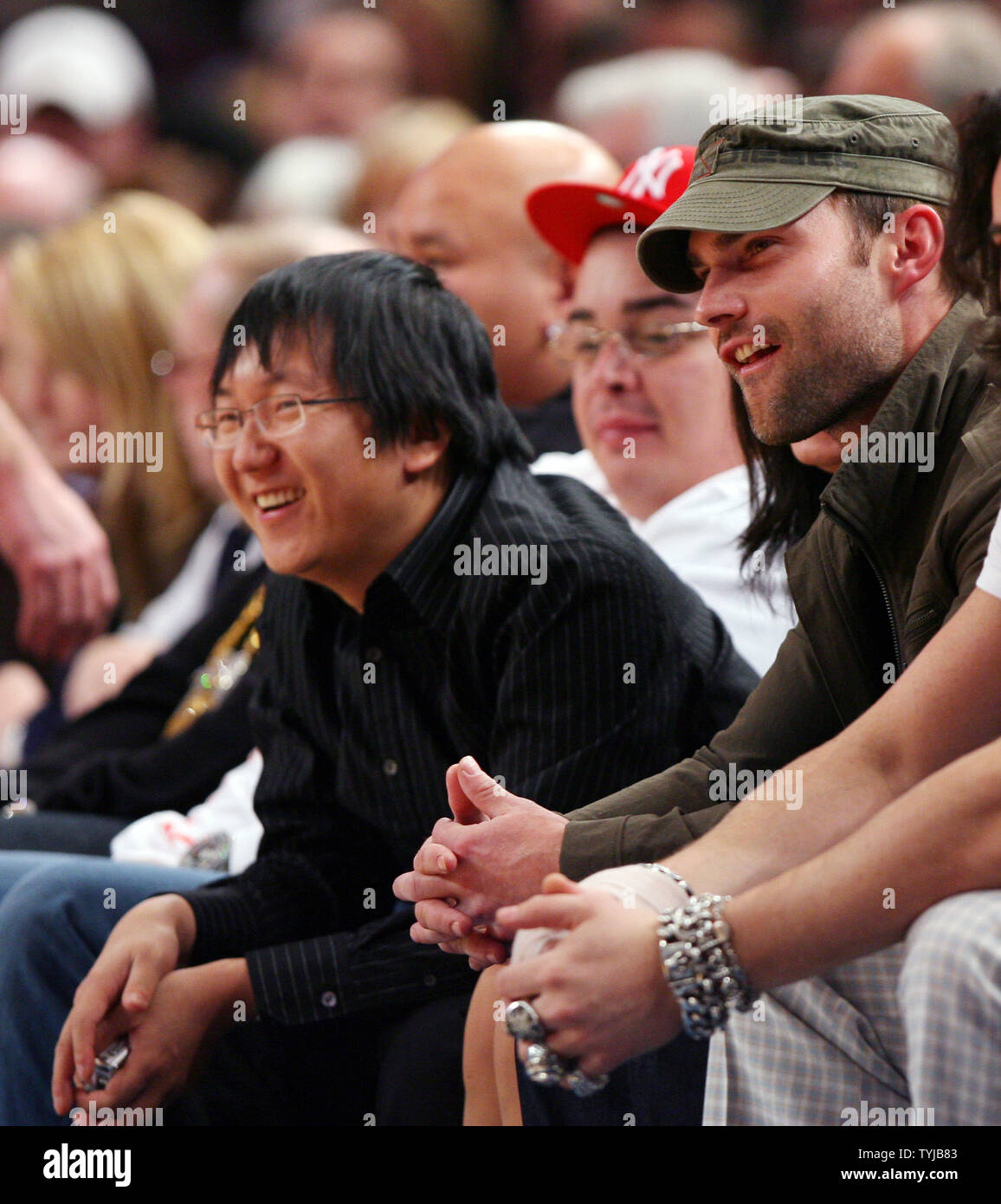 Masi Oka (L) and Sean William Scott watch the New York Knicks play the ...