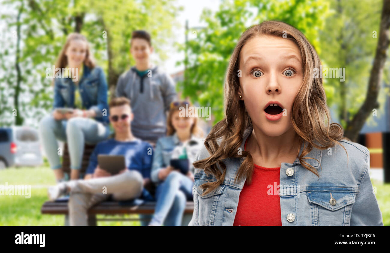 surprised or shocked teenage girl over friends Stock Photo - Alamy