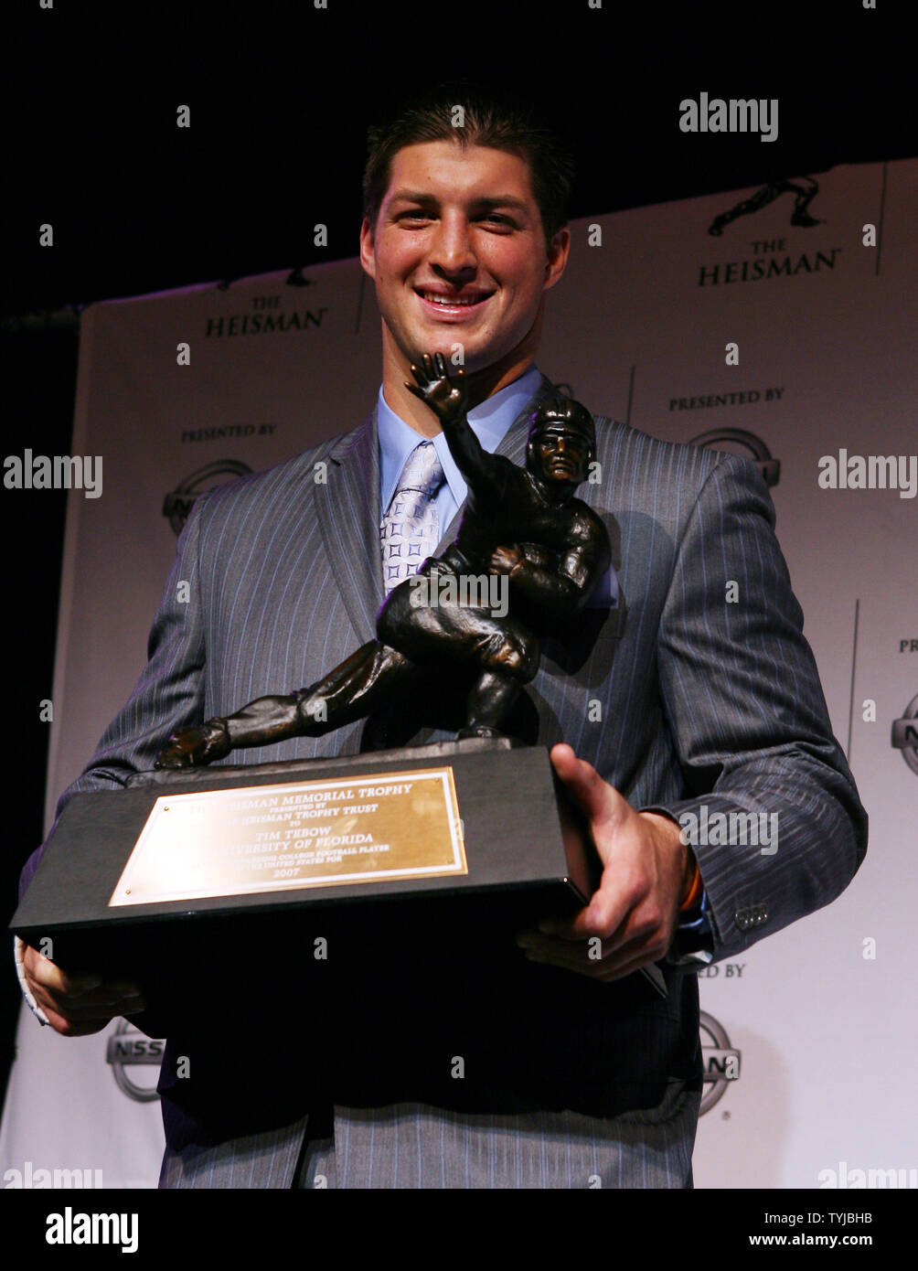 University of Florida quarterback, Tim Tebow, holds the Heisman Trophy ...