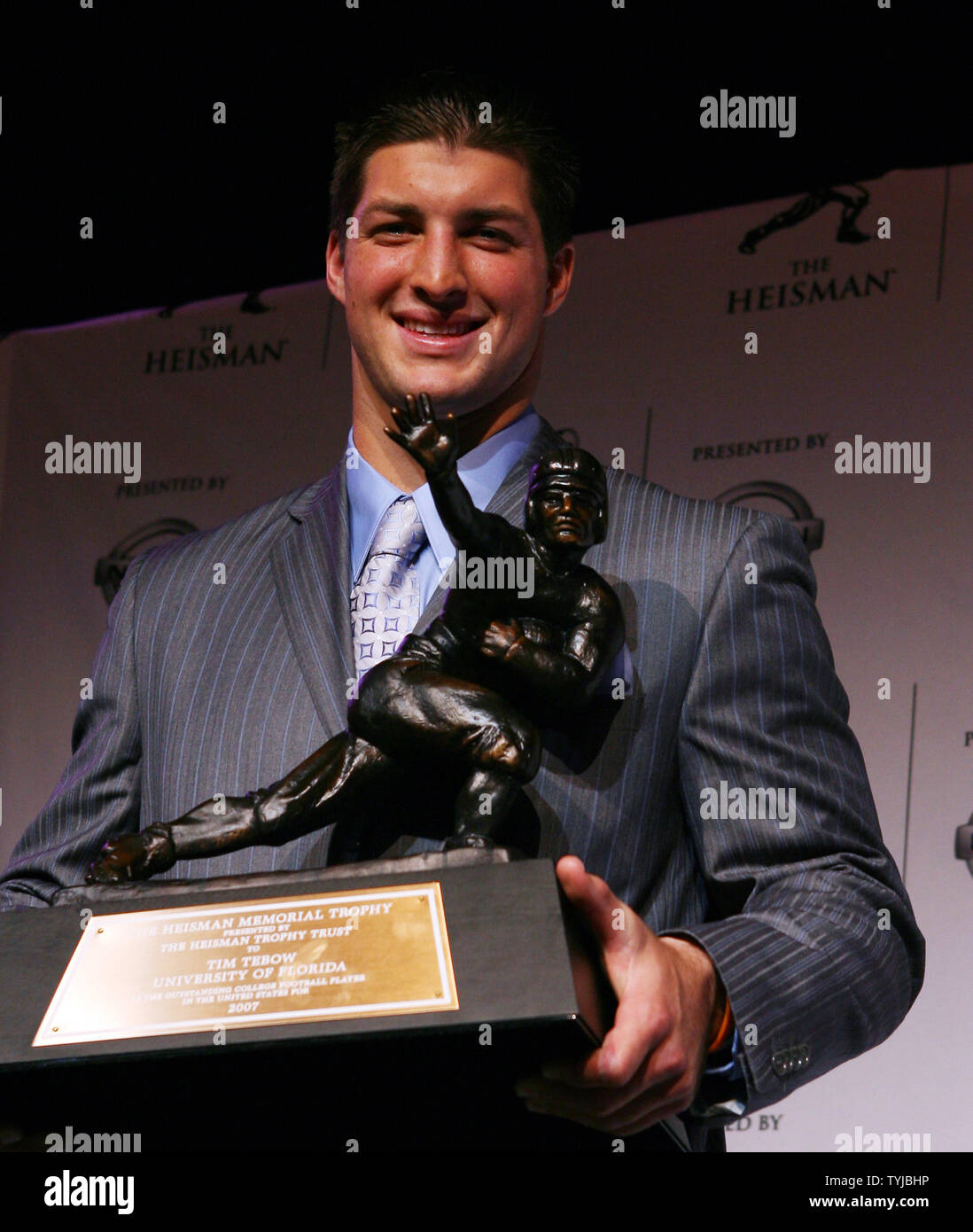 University of Florida quarterback, Tim Tebow, holds the Heisman Trophy ...