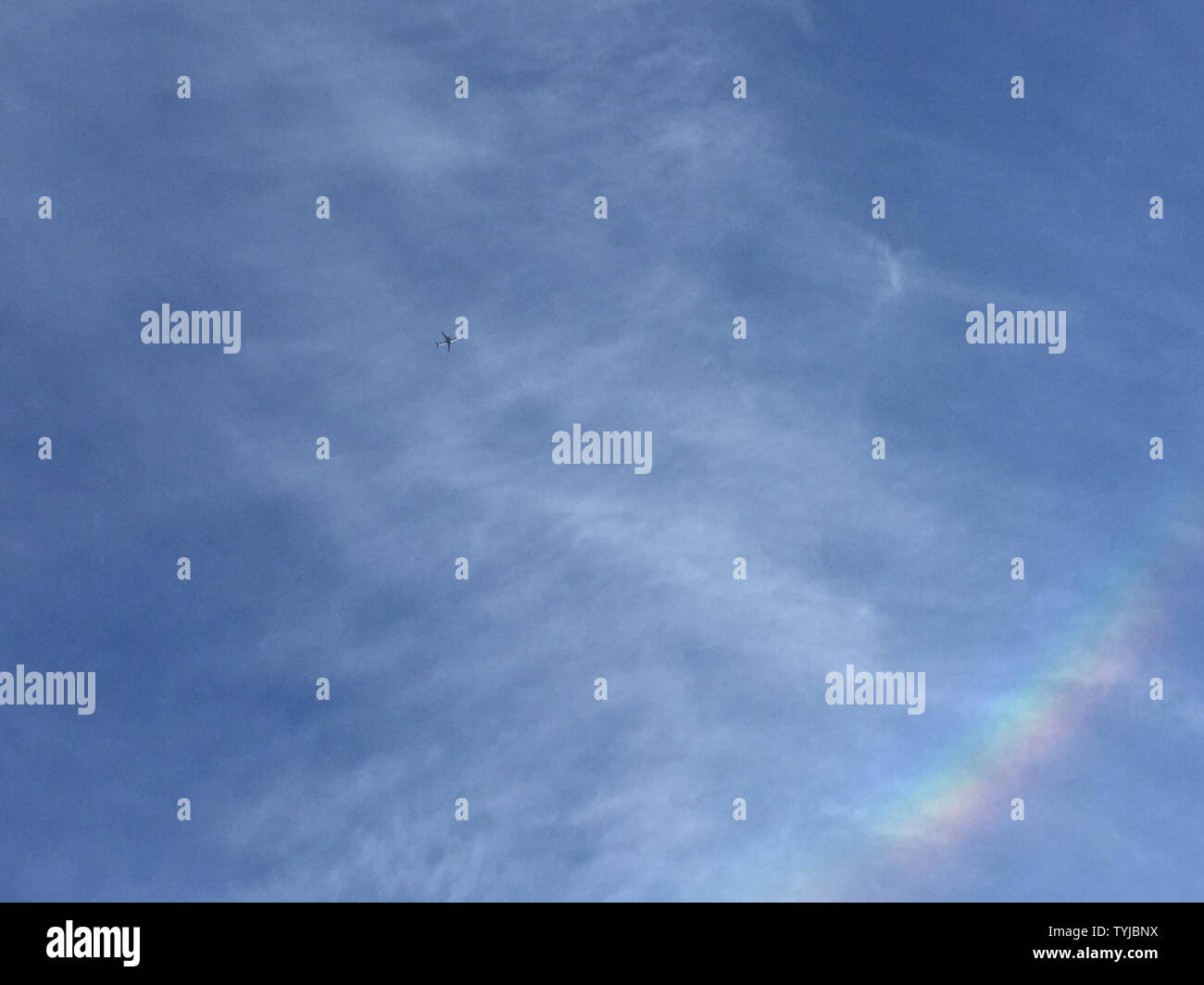 Blue sky with rainbow cloud, no rain, and airplane, CA Stock Photo - Alamy