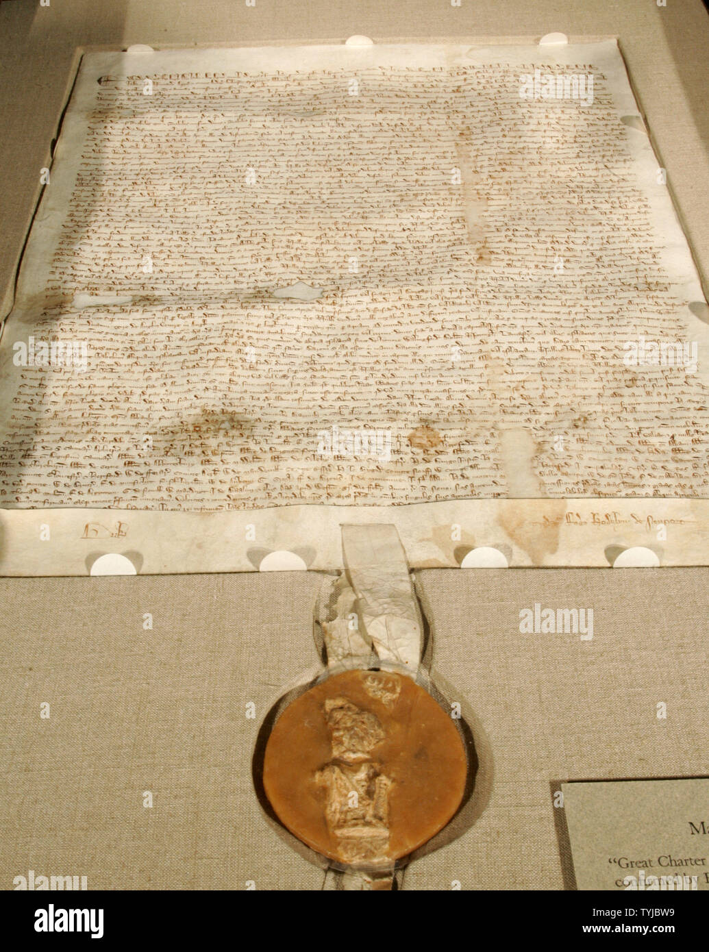 The Magna Carta, with its seal of King Edward I, is displayed in a case ...