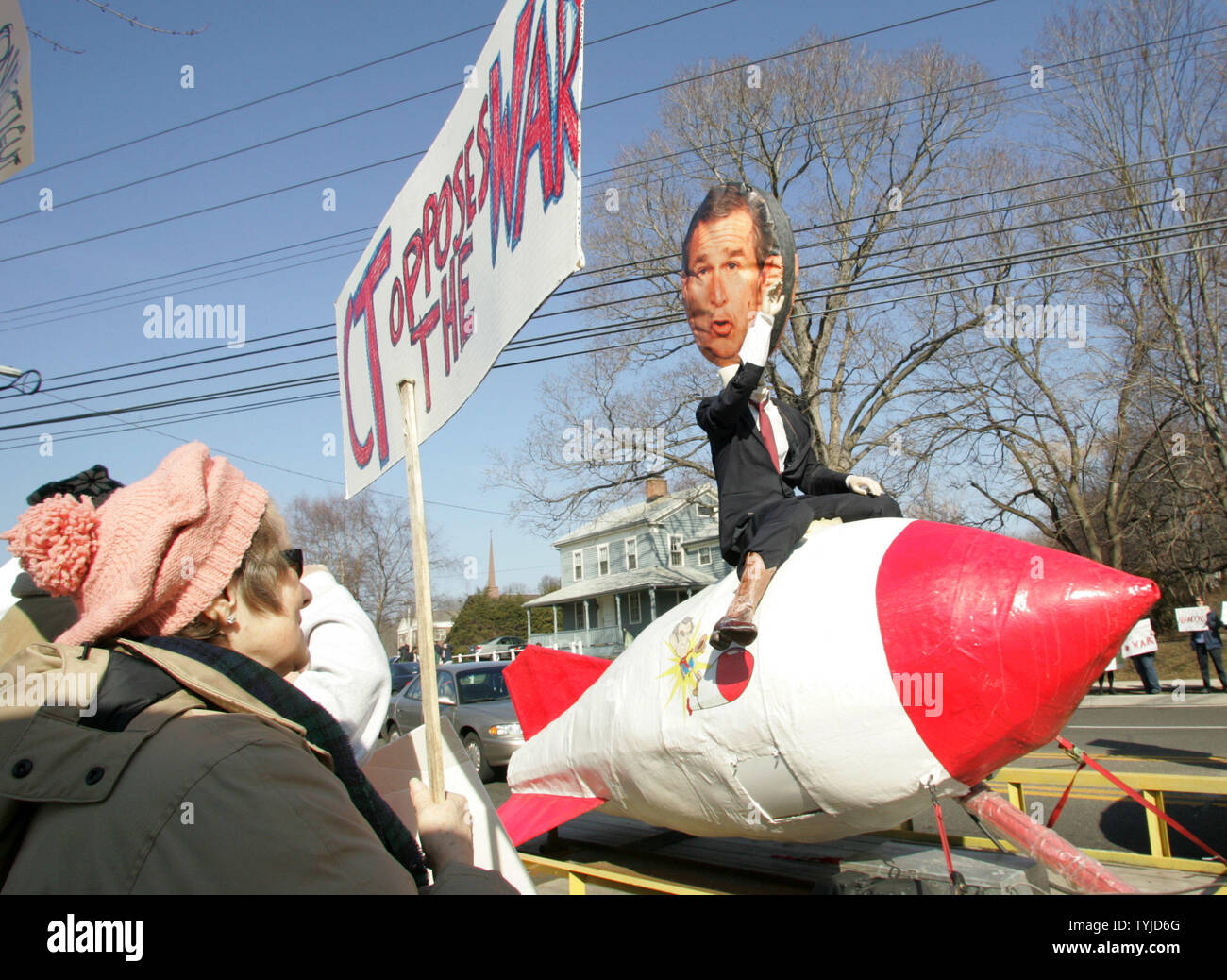 Anti-war protesters stand along the road as a giant effigy of President ...