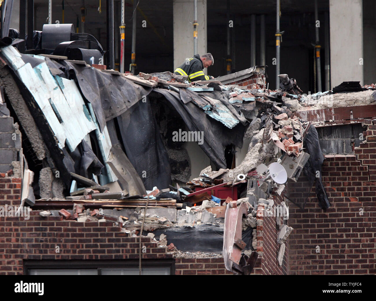 A New York City fire fighter hangs his head amid the rubble after a ...