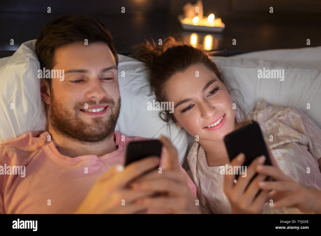 happy couple using smartphones in bed at night Stock Photo - Alamy