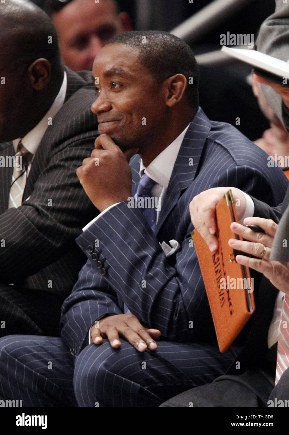New York Knicks head coach Isiah Thomas sits and smiles in the first ...
