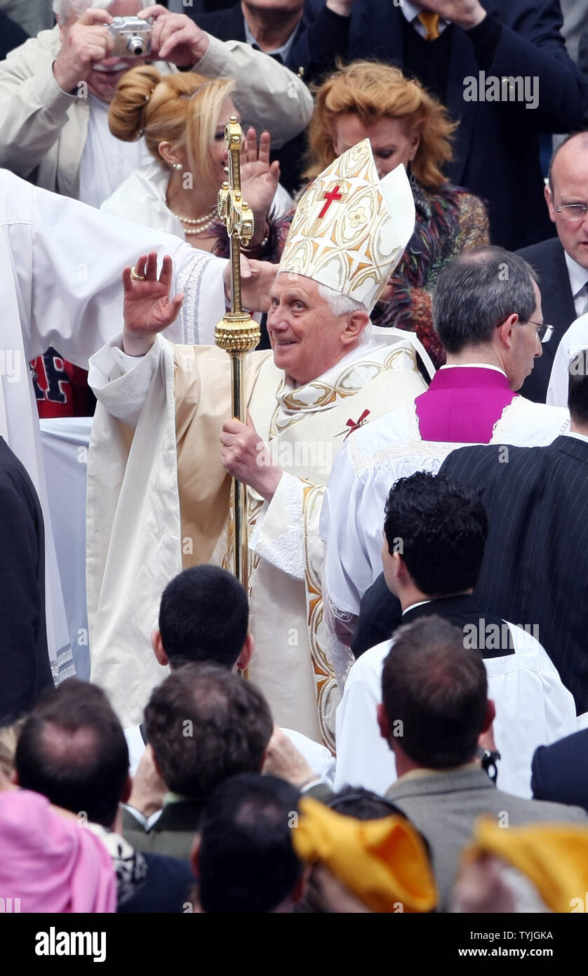 Pope Benedict XVI raises his hand as he walks to the Alter before ...