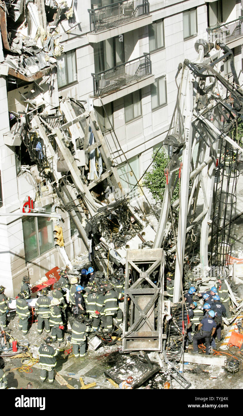 Rescue workers search for a victim of the construction crane collapse ...