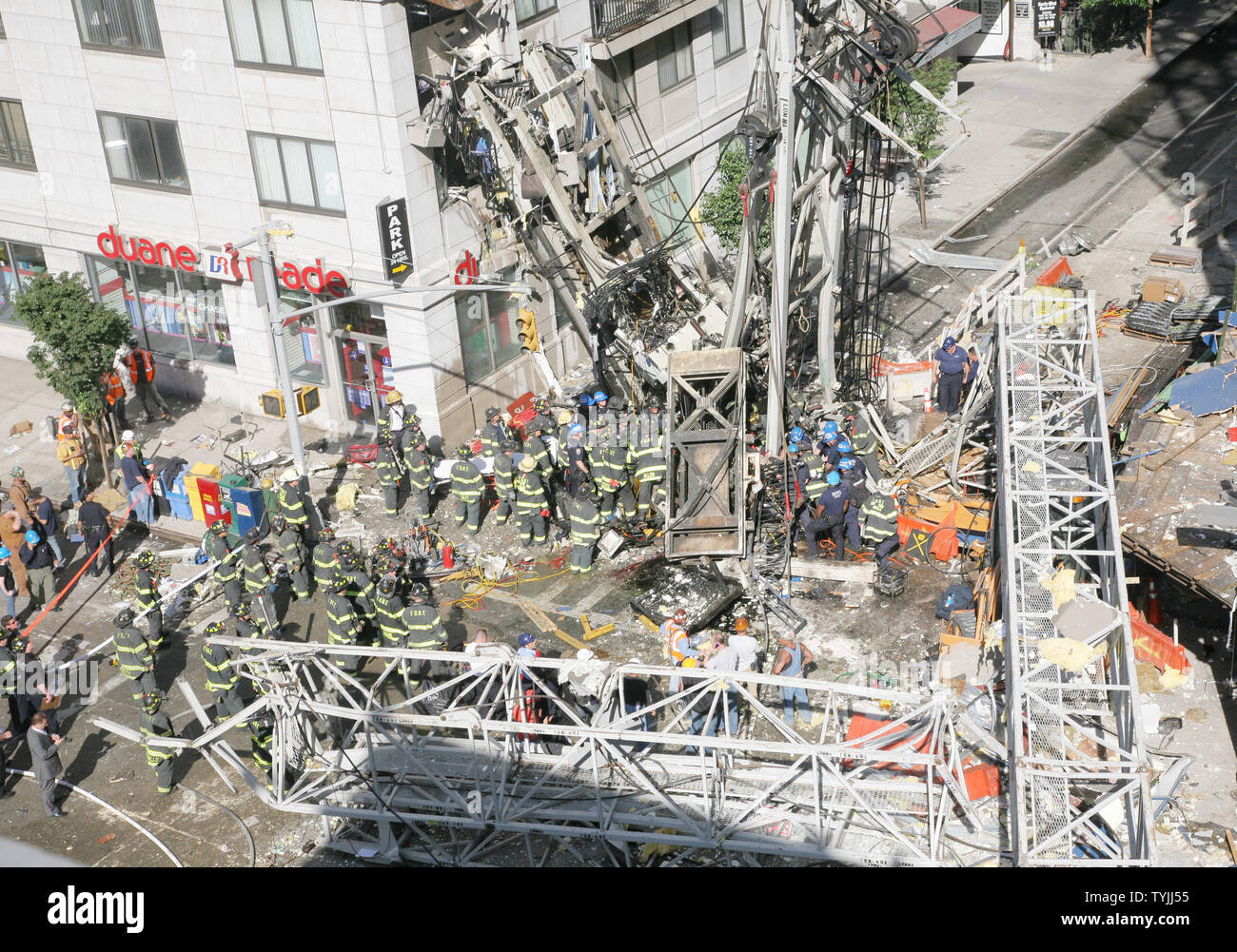 Rescue workers search for a victim of the construction crane collapse ...