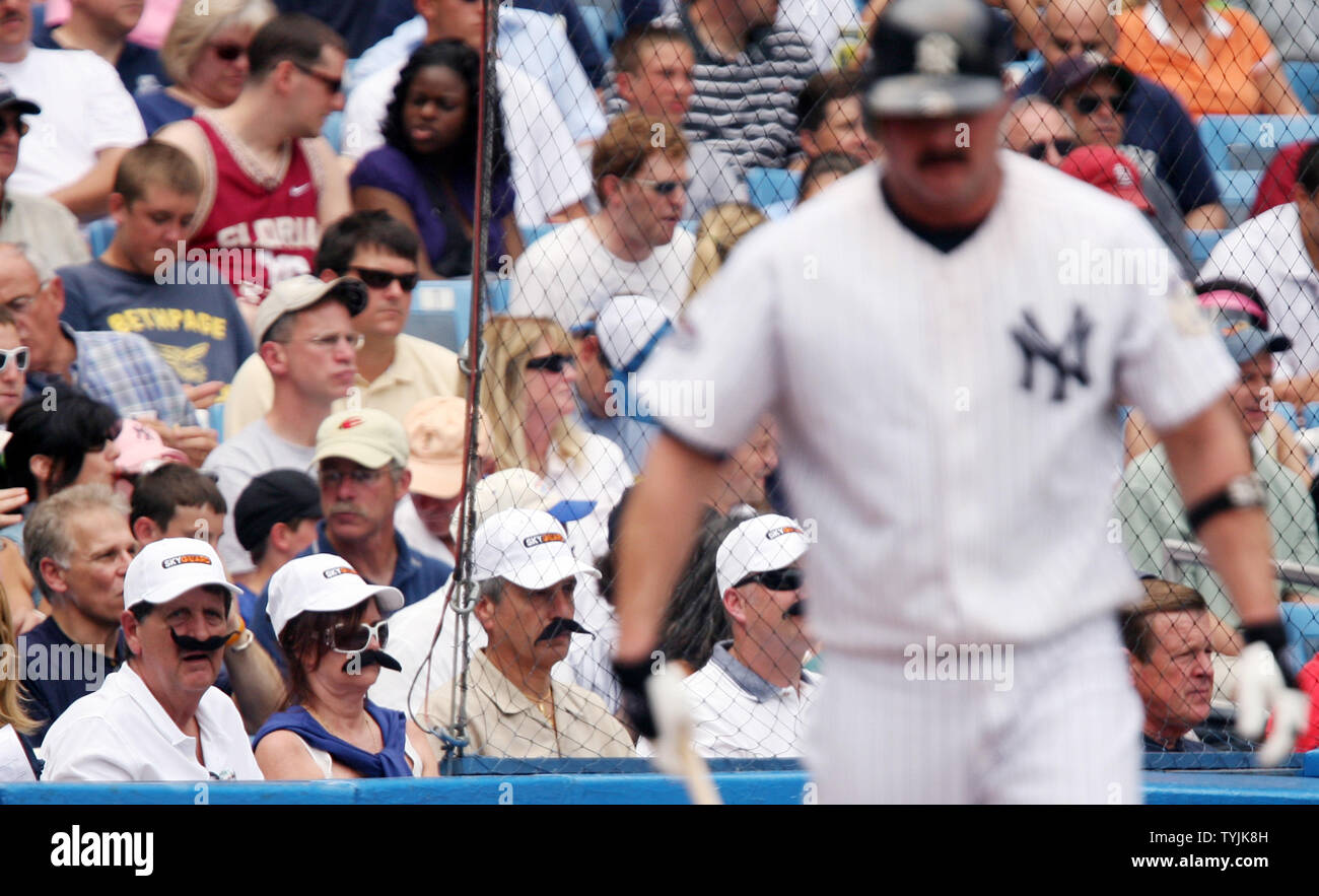 Fans wearing fake mustaches watch New York Yankees Jason Giambi in the ...