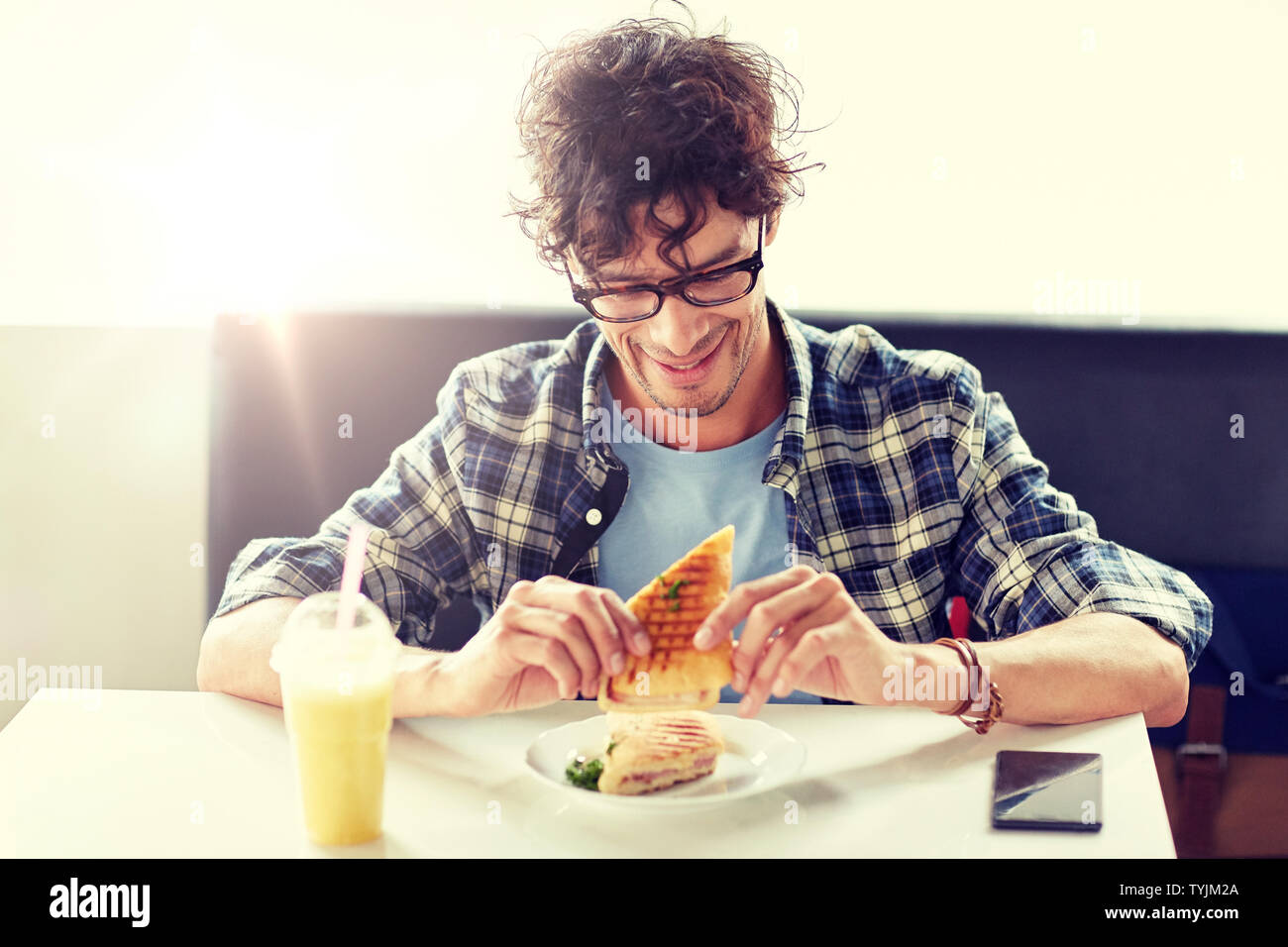 happy man eating sandwich at cafe for lunch Stock Photo - Alamy