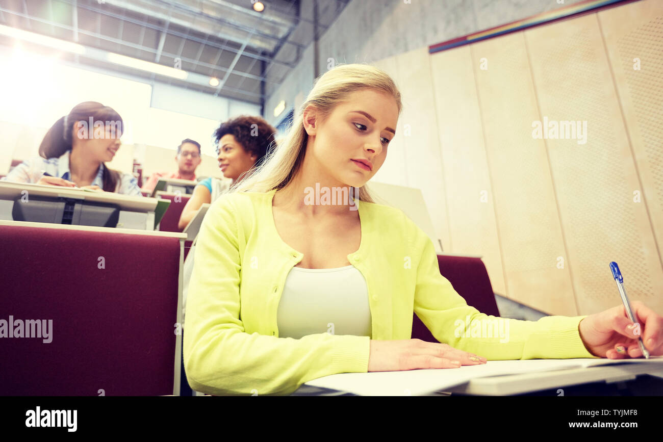 student girl writing to notebook at lecture hall Stock Photo - Alamy