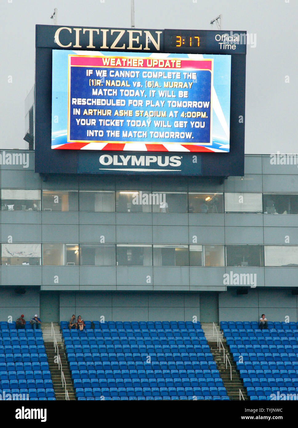 People keep dry beneath the overhang in the upper stadium seats as ...