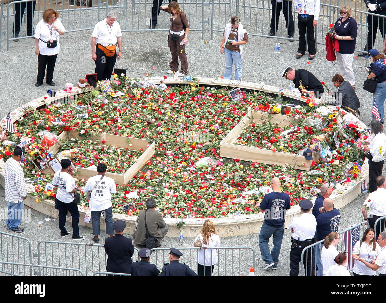 People gather around the reflecting pool which is filled with flowers ...