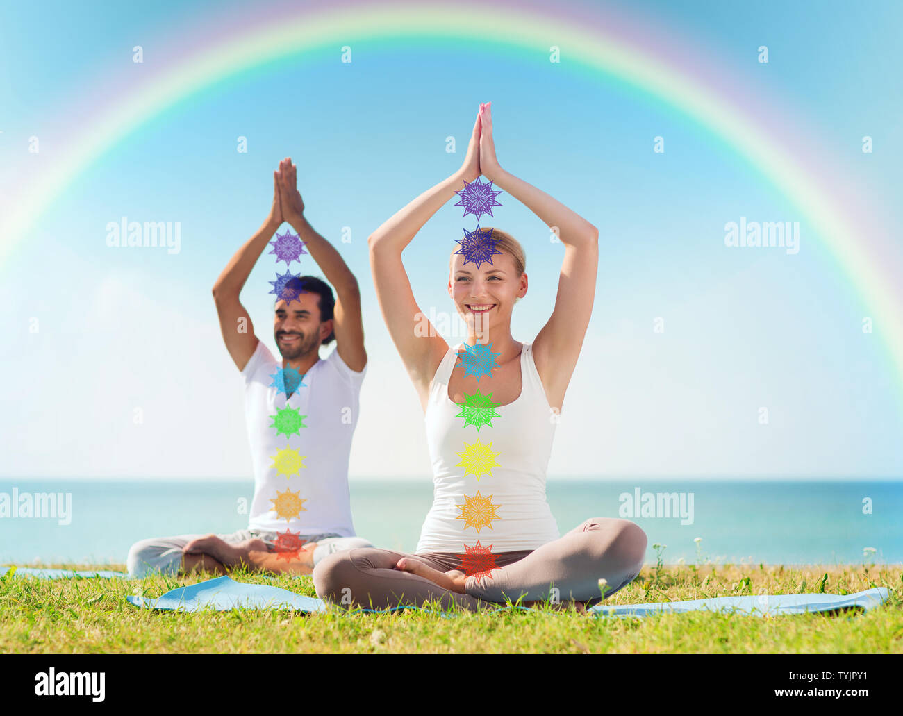 couple doing yoga in lotus pose with seven chakras Stock Photo - Alamy