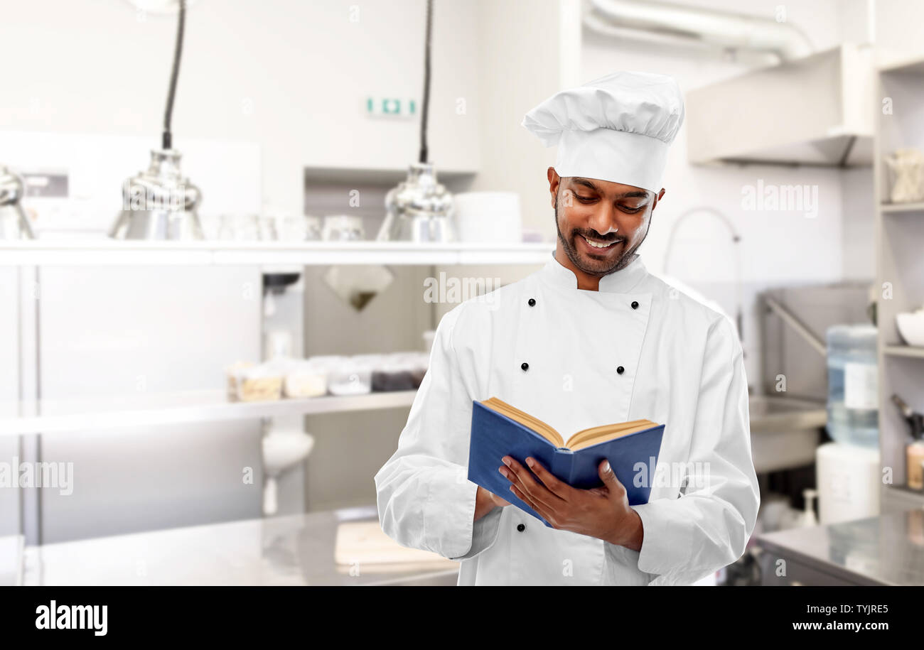 happy indian chef reading cookbook at kitchen Stock Photo - Alamy