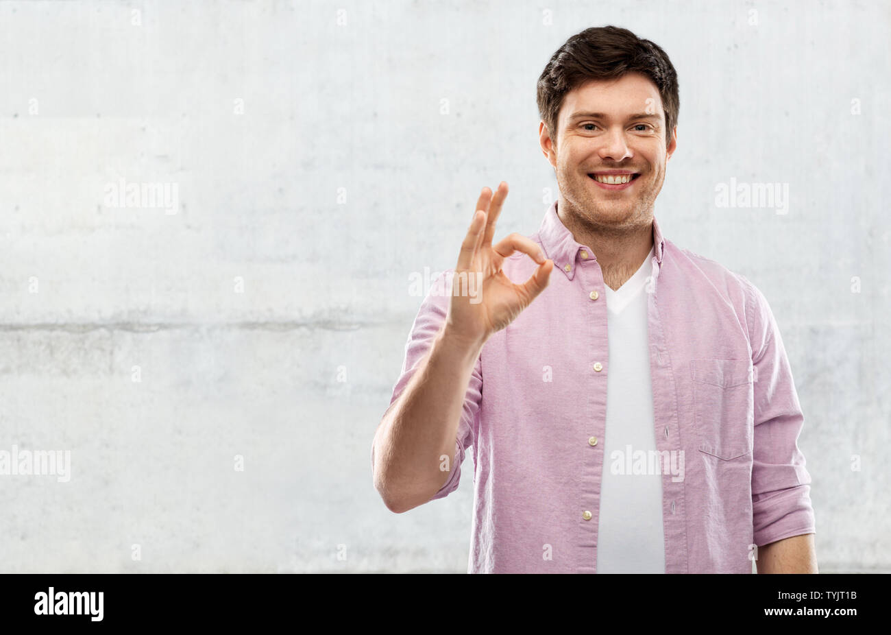 smiling young man showing ok hand sign Stock Photo - Alamy