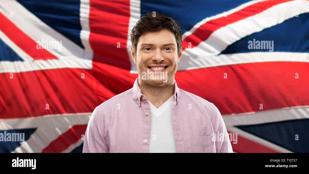smiling young man over british flag background Stock Photo - Alamy