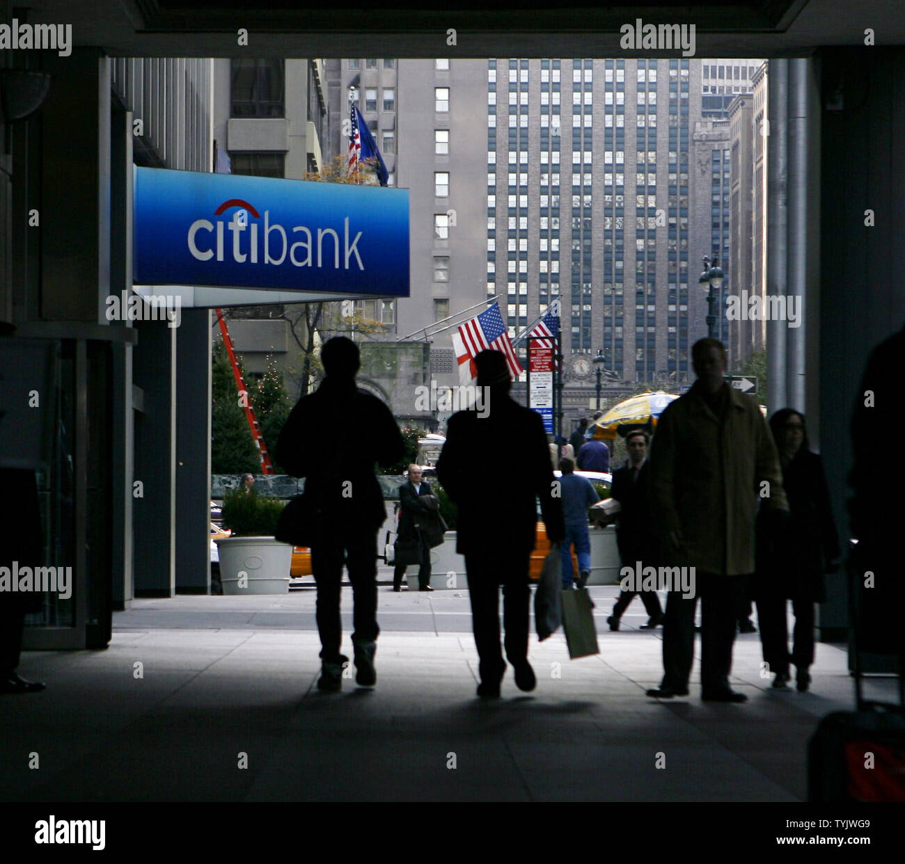 People walk past a Citibank branch located next to Citigroup ...