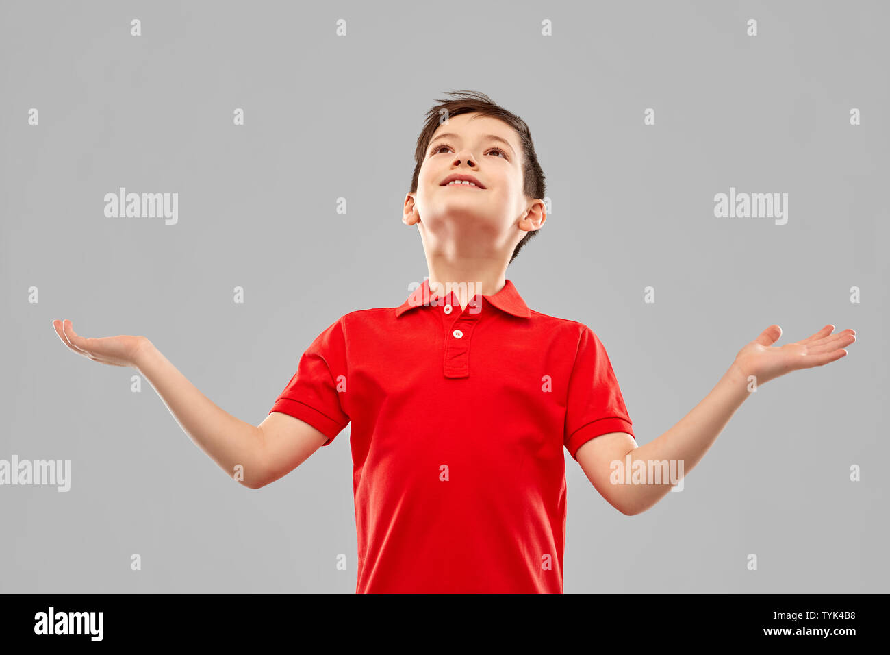 happy grateful boy in red t-shirt looking up Stock Photo - Alamy