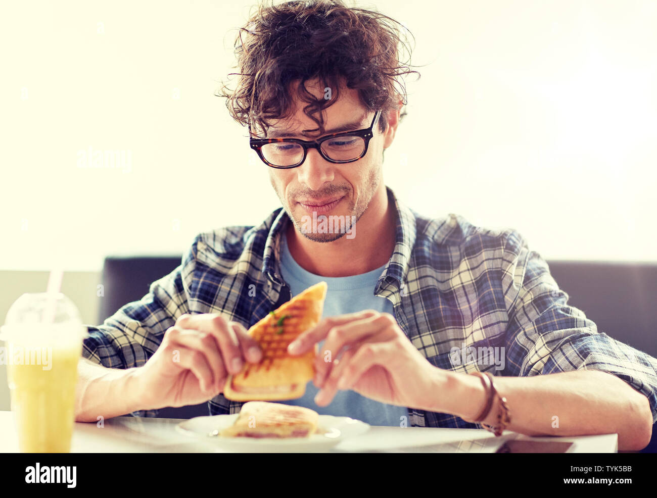 happy man eating sandwich at cafe for lunch Stock Photo - Alamy