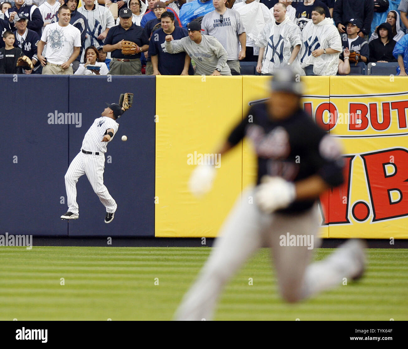 New York Yankees Melky Cabrera leaps for a ball while New York Mets ...