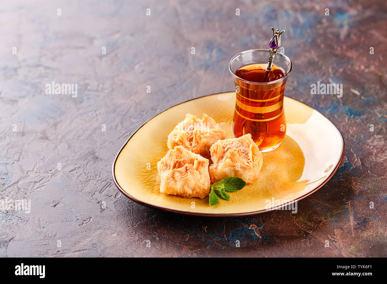 Middle Eastern or Arabic tea with mint in a traditional glass cup and ...
