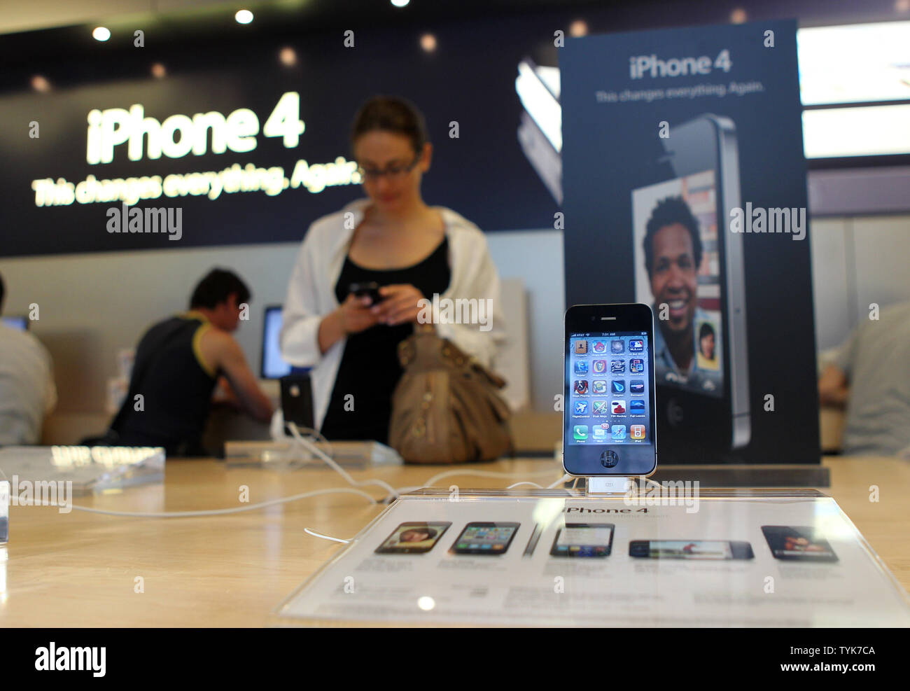 An Apple customer looks at the new Apple iPhone 4 at the Apple Store on ...